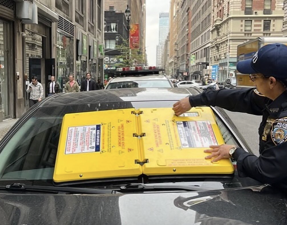 What are those yellow plastic boxes on NYC cars' windshields?